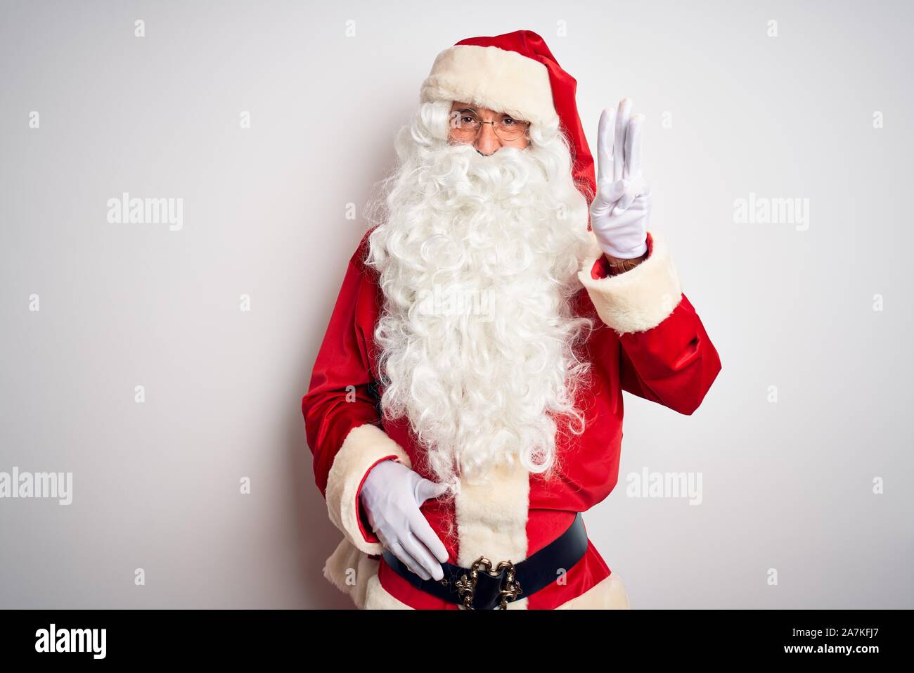 Middle age handsome man wearing Santa costume standing over isolated ...
