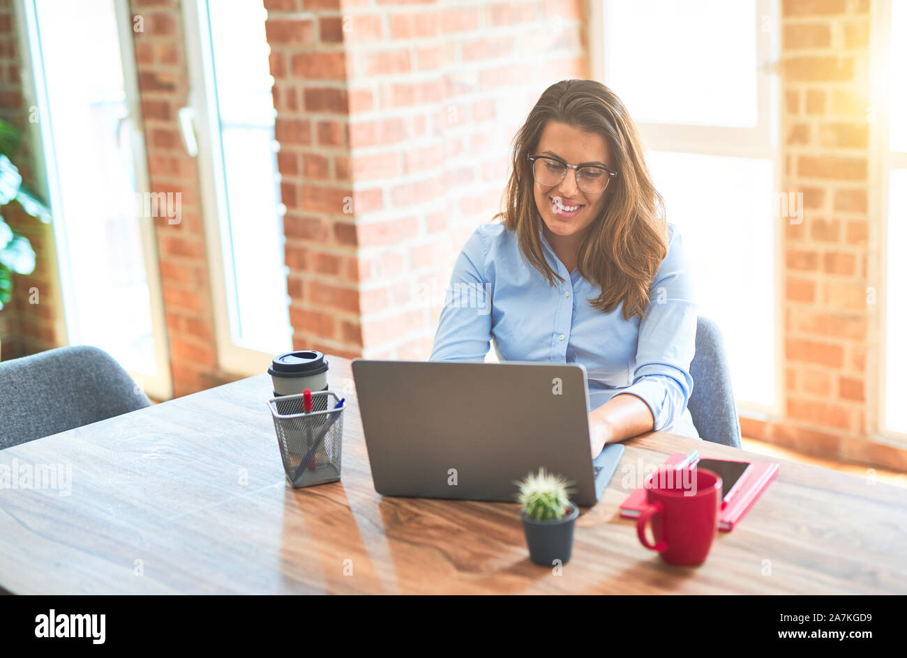 Young business woman sitting at desk working using computer laptop ...