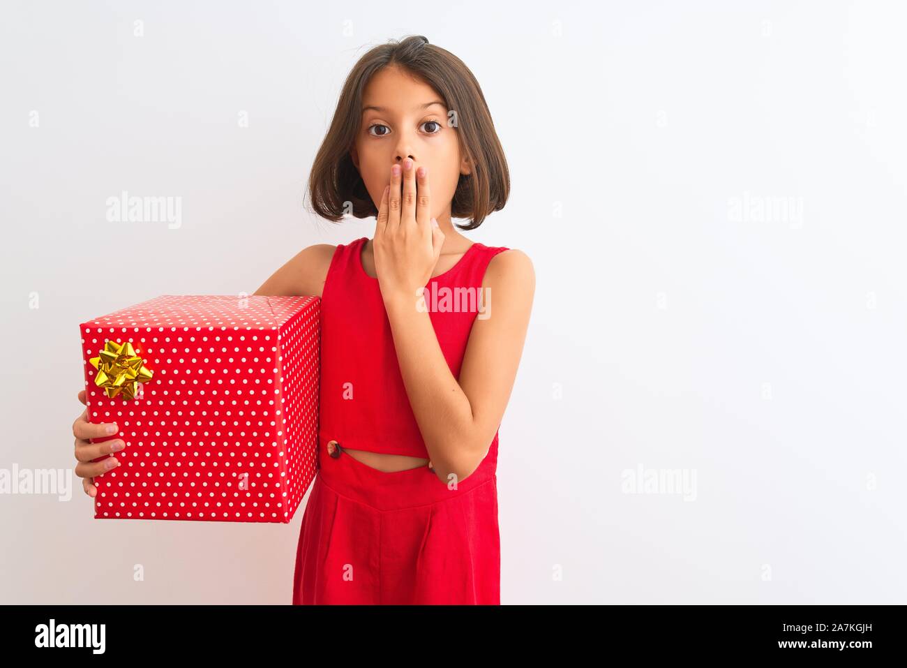 Beautiful child girl holding birthday gift standing over isolated white ...