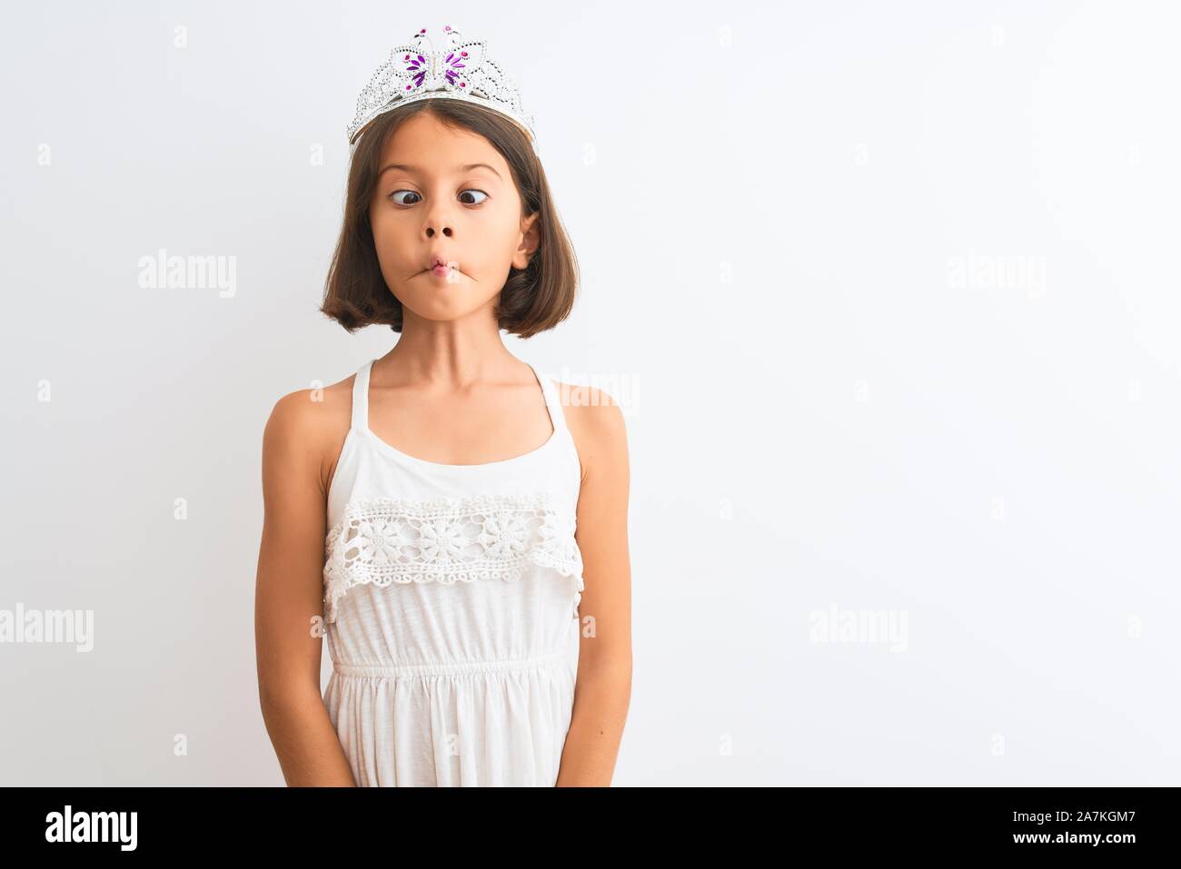 Beautiful child girl wearing princess crown standing over isolated ...