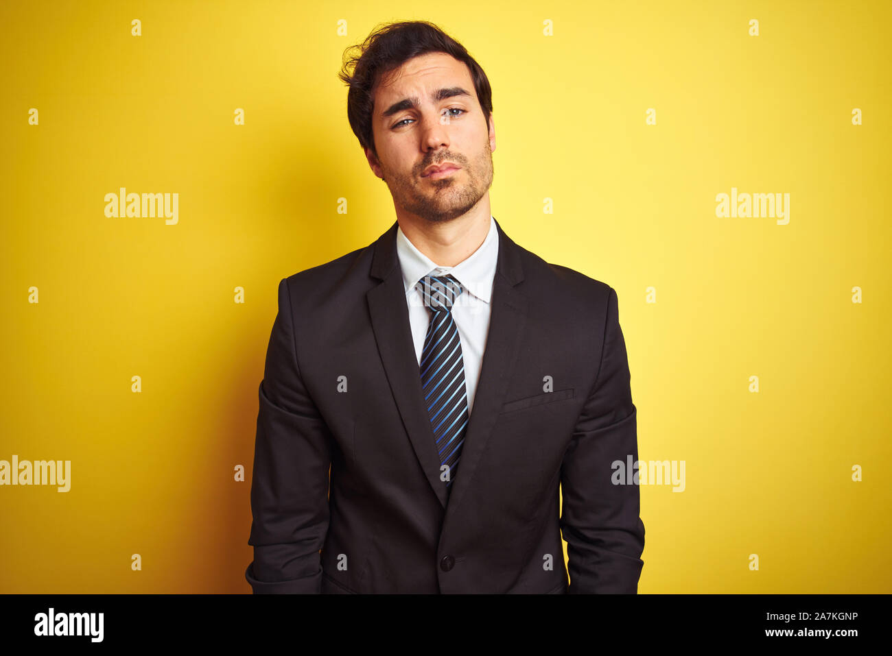 Young handsome businessman wearing suit and tie standing over isolated ...