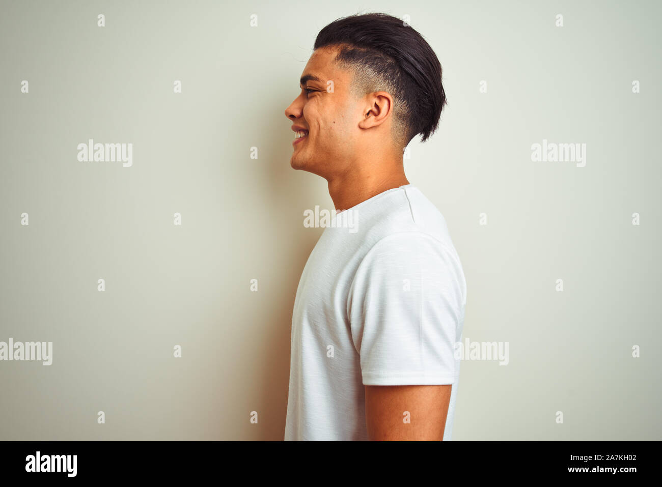 Young brazilian man wearing t-shirt standing over isolated white ...