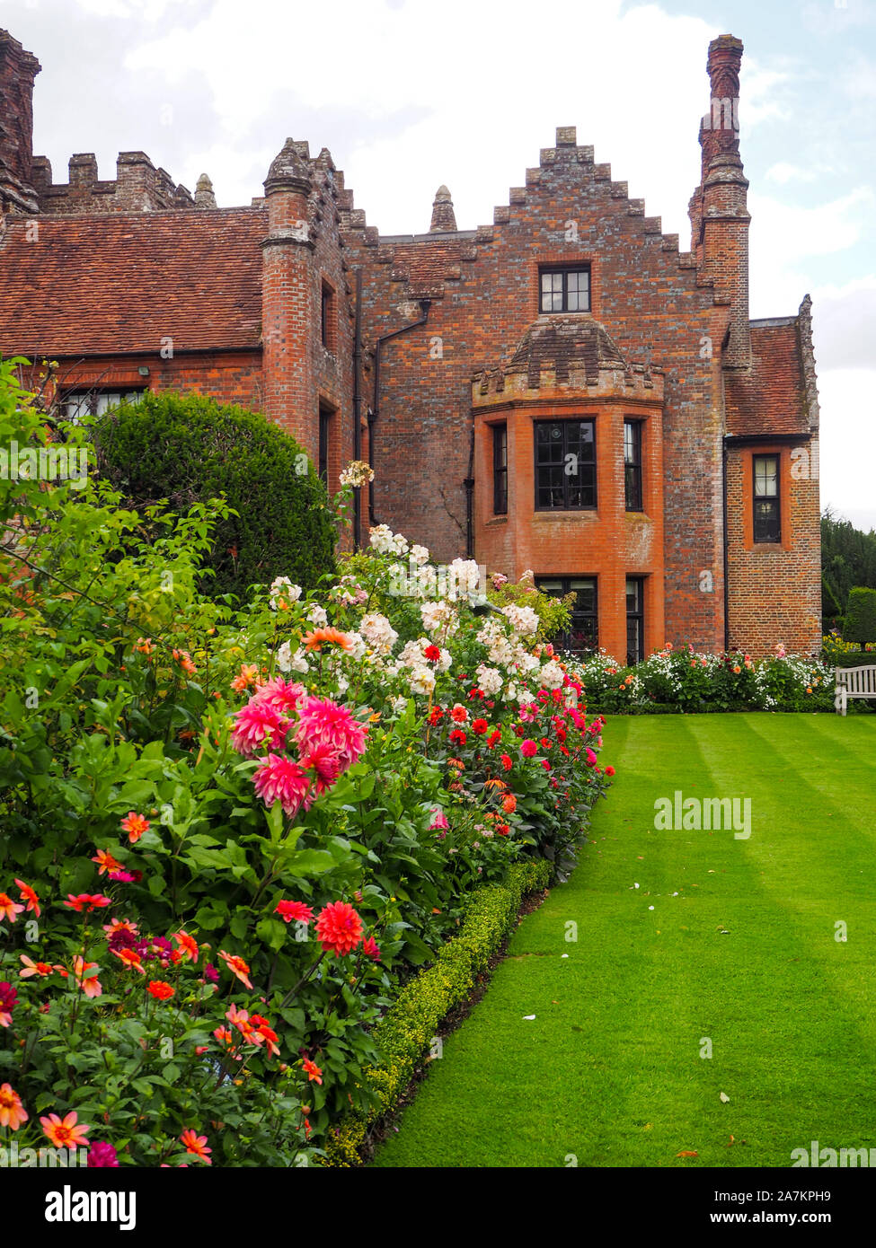 Chenies Manor house facing south west, framed by plant borders packed ...