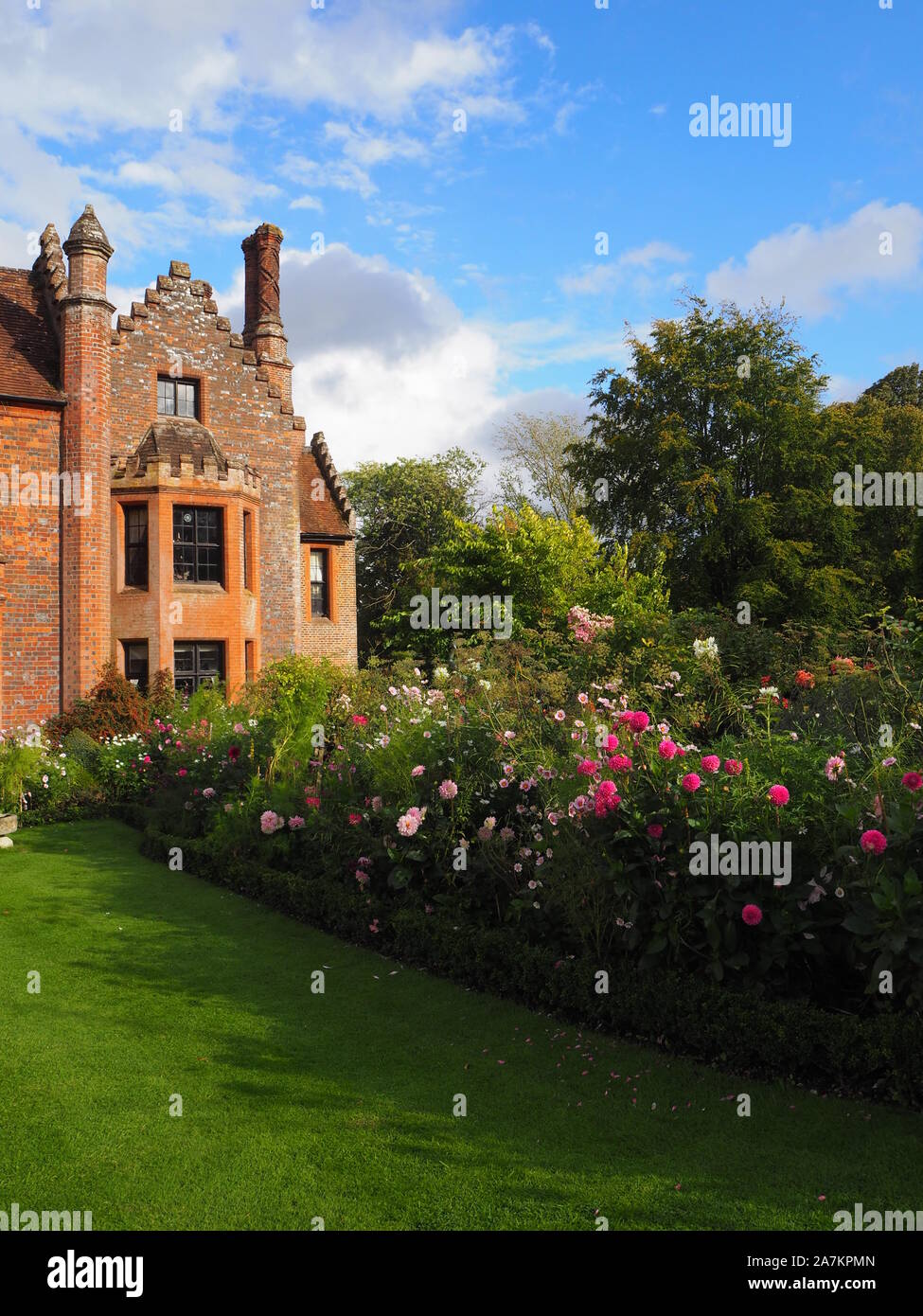 Chenies Manor house facing south west, framed by plant borders packed ...