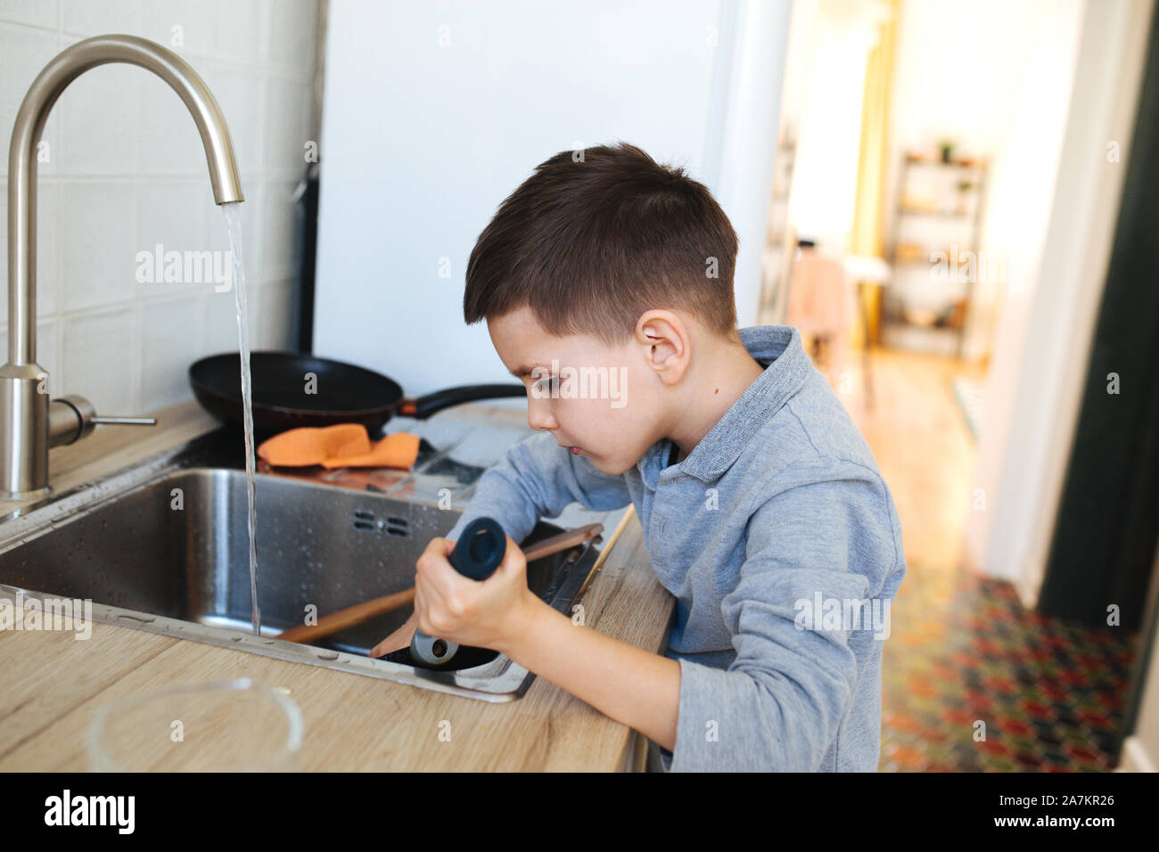 Little boy washing dishes in the kitchen at home Stock Photo - Alamy