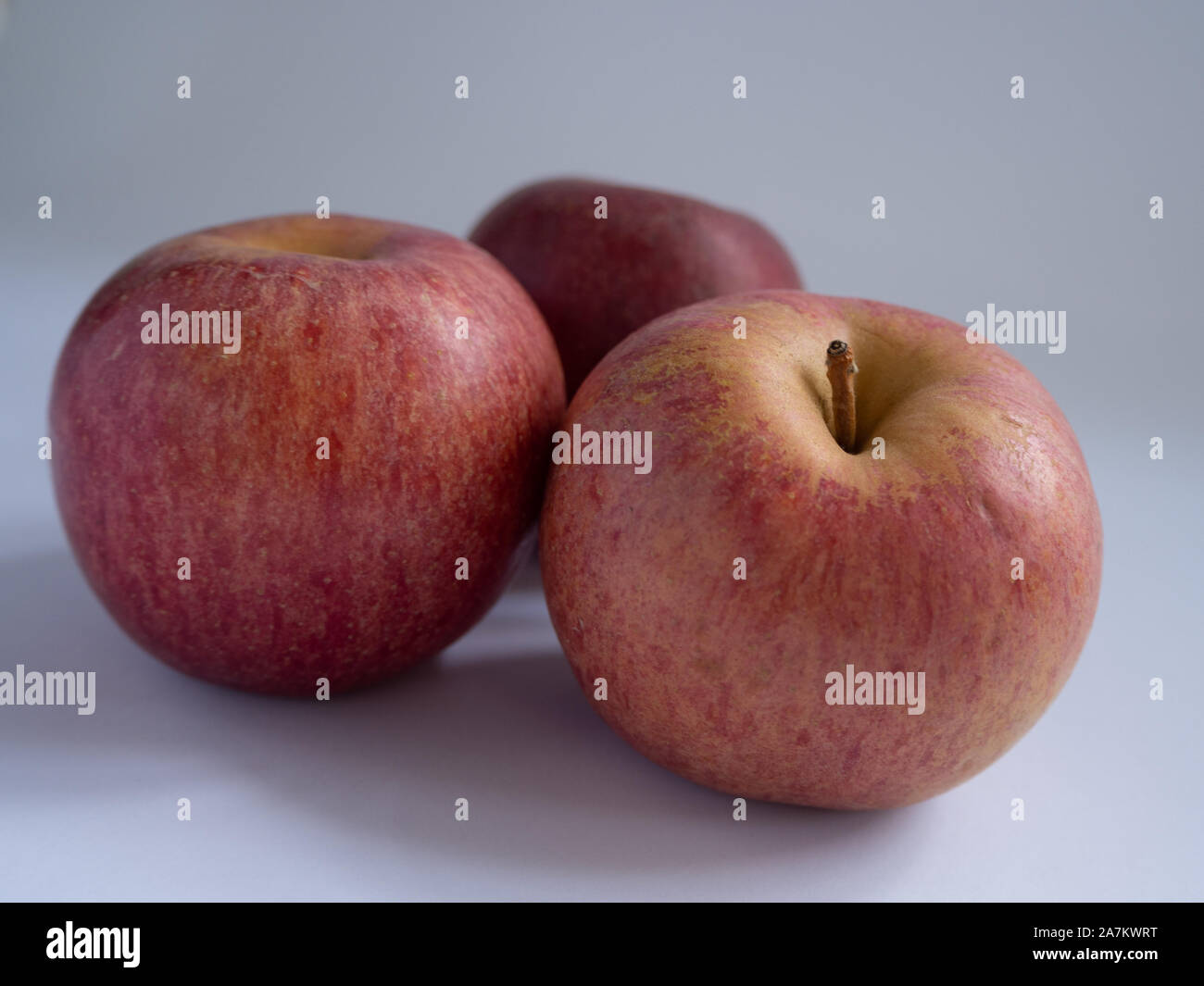 Three red apples on a white background Stock Photo - Alamy
