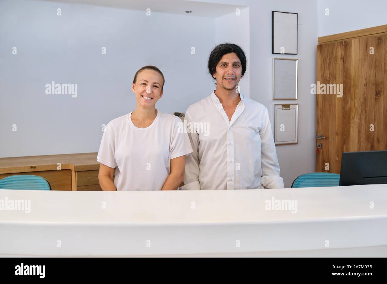 Portrait of hotel workers at the workplace, man and woman receptionists ...
