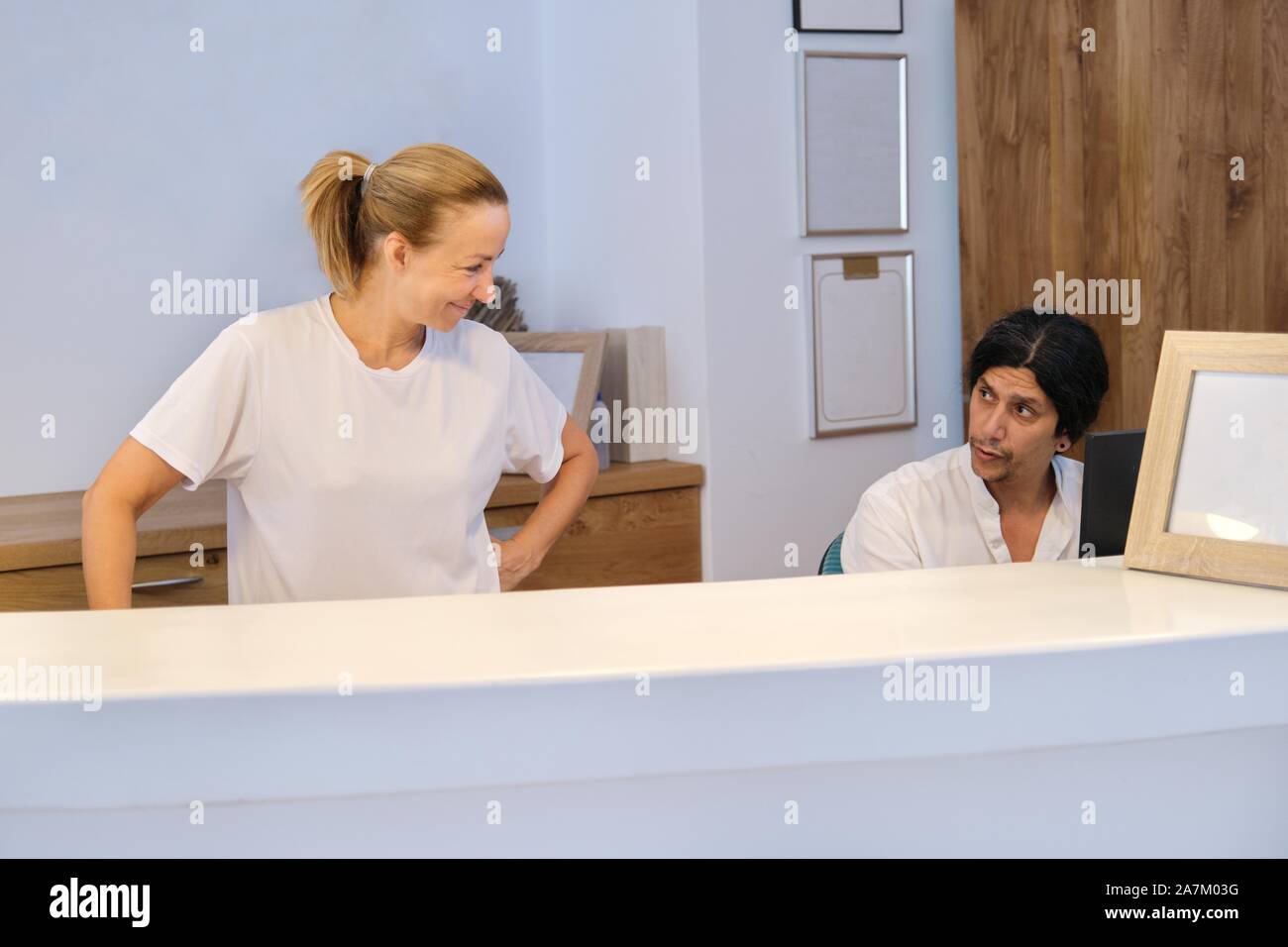 Portrait of hotel workers at the workplace, man and woman receptionists ...