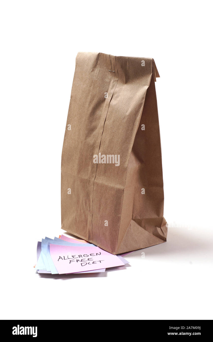 Brown paper closed bag with sticky note with text pasted to it ...