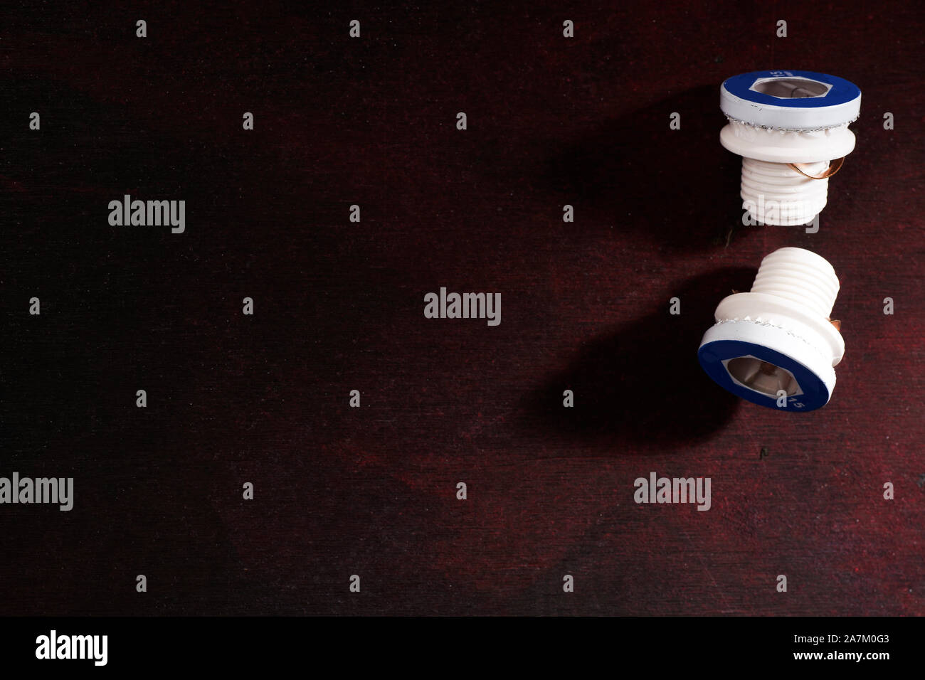 Electrical screw-in fuses on dark red-black background with copy space ...