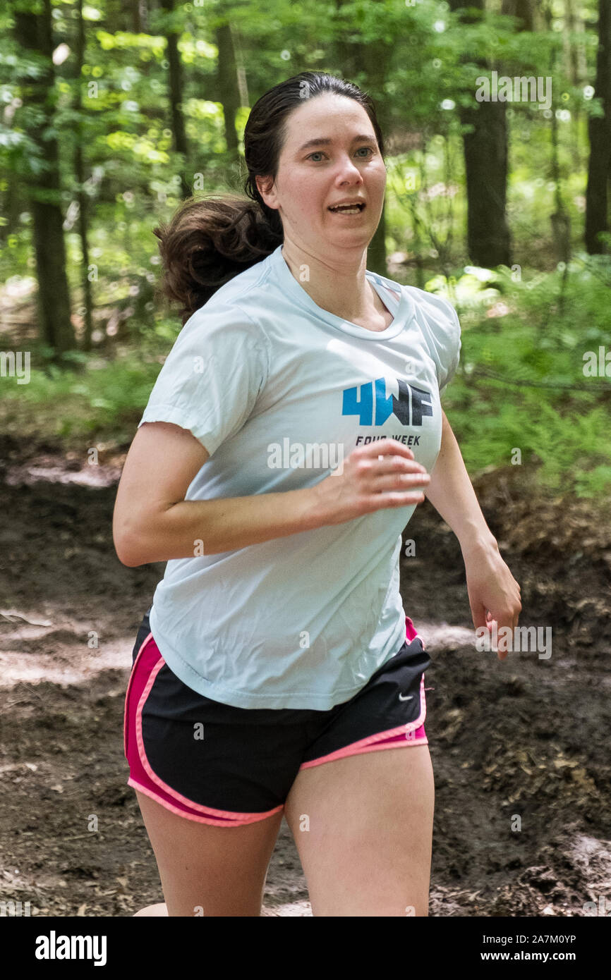 People running in a race along a wooded trail Stock Photo - Alamy