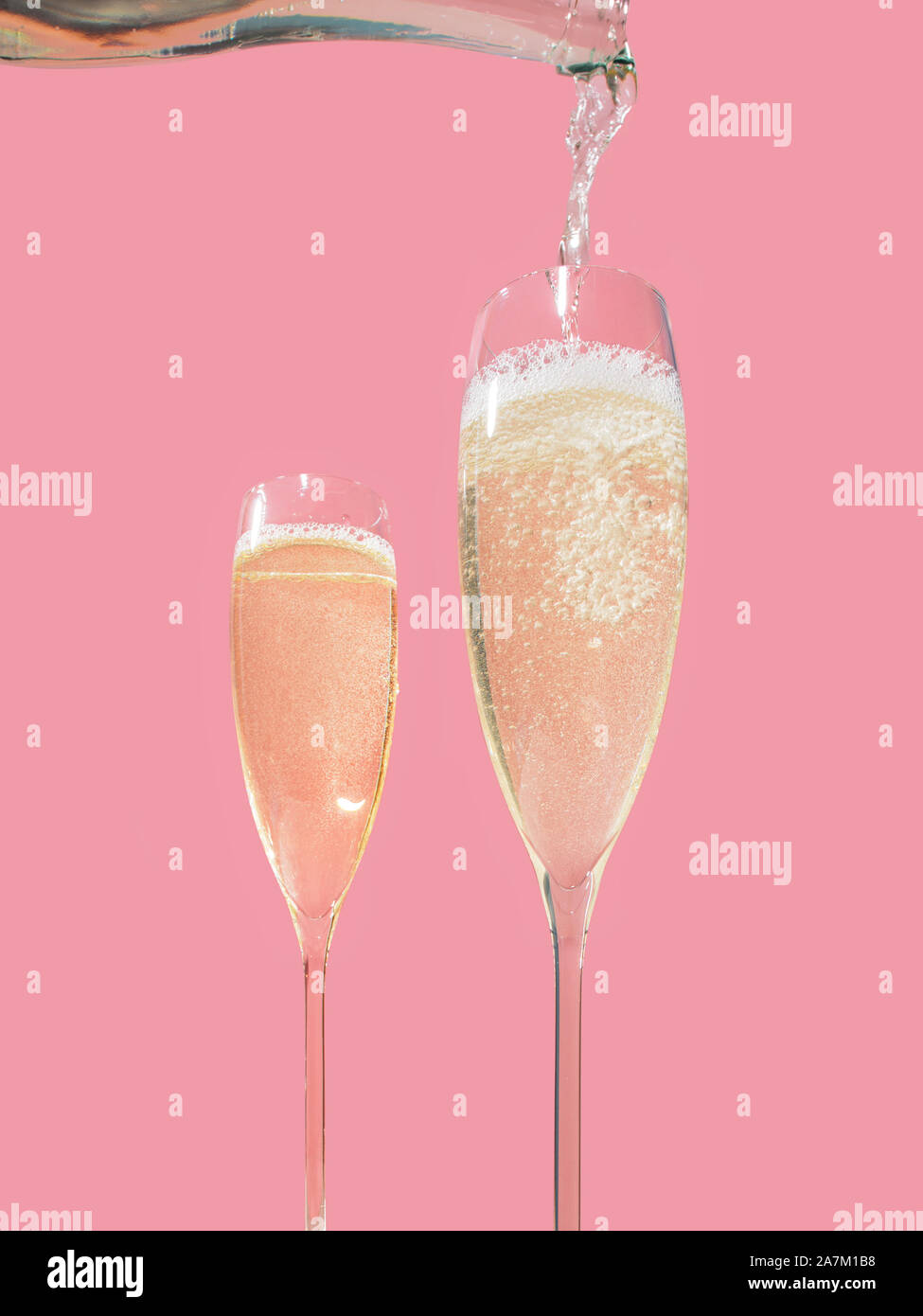 Valdobbiadene Prosecco flutes and a bottle, pink background, in pop ...