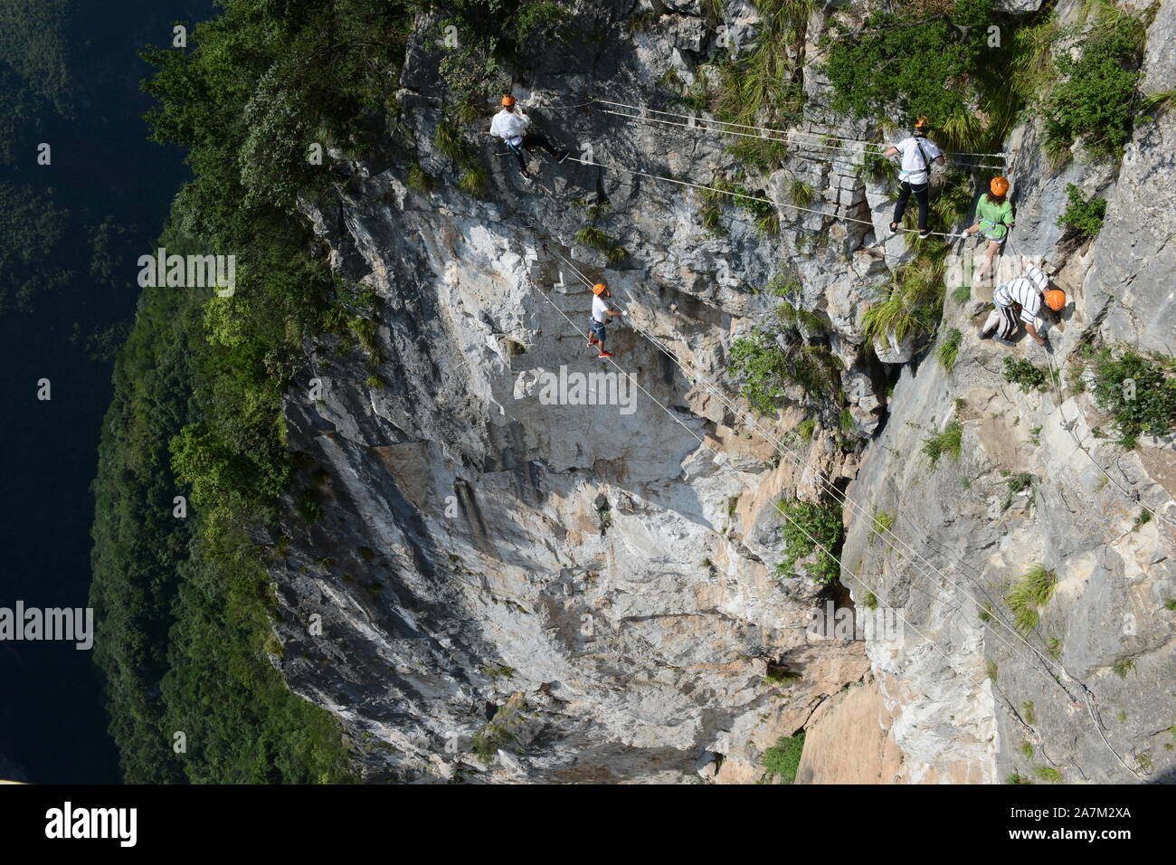 Tourists climb the Cloud Bridge, part of the Via Ferrata project, at ...