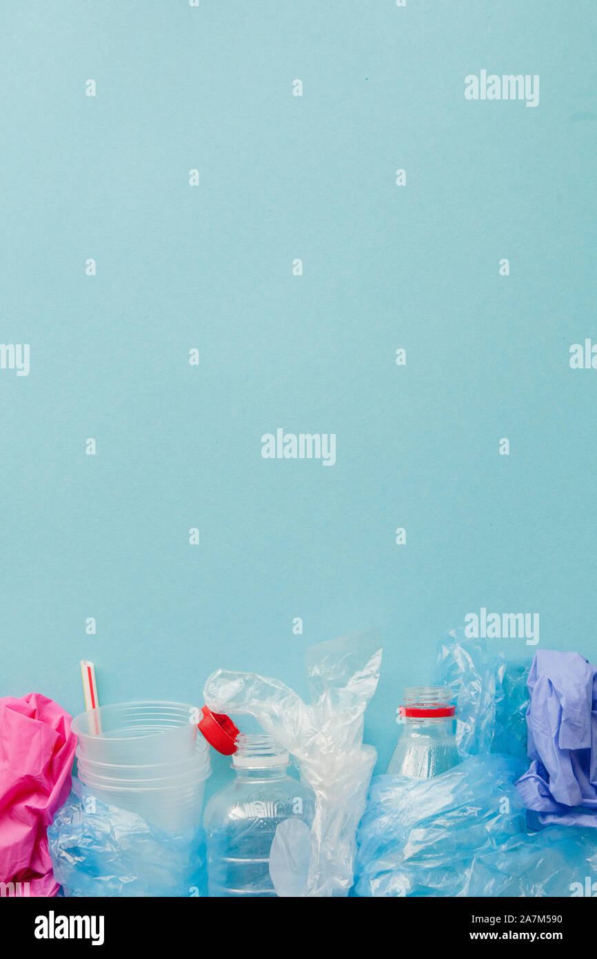Top view of various kinds of disposable plastic waste on blue ...