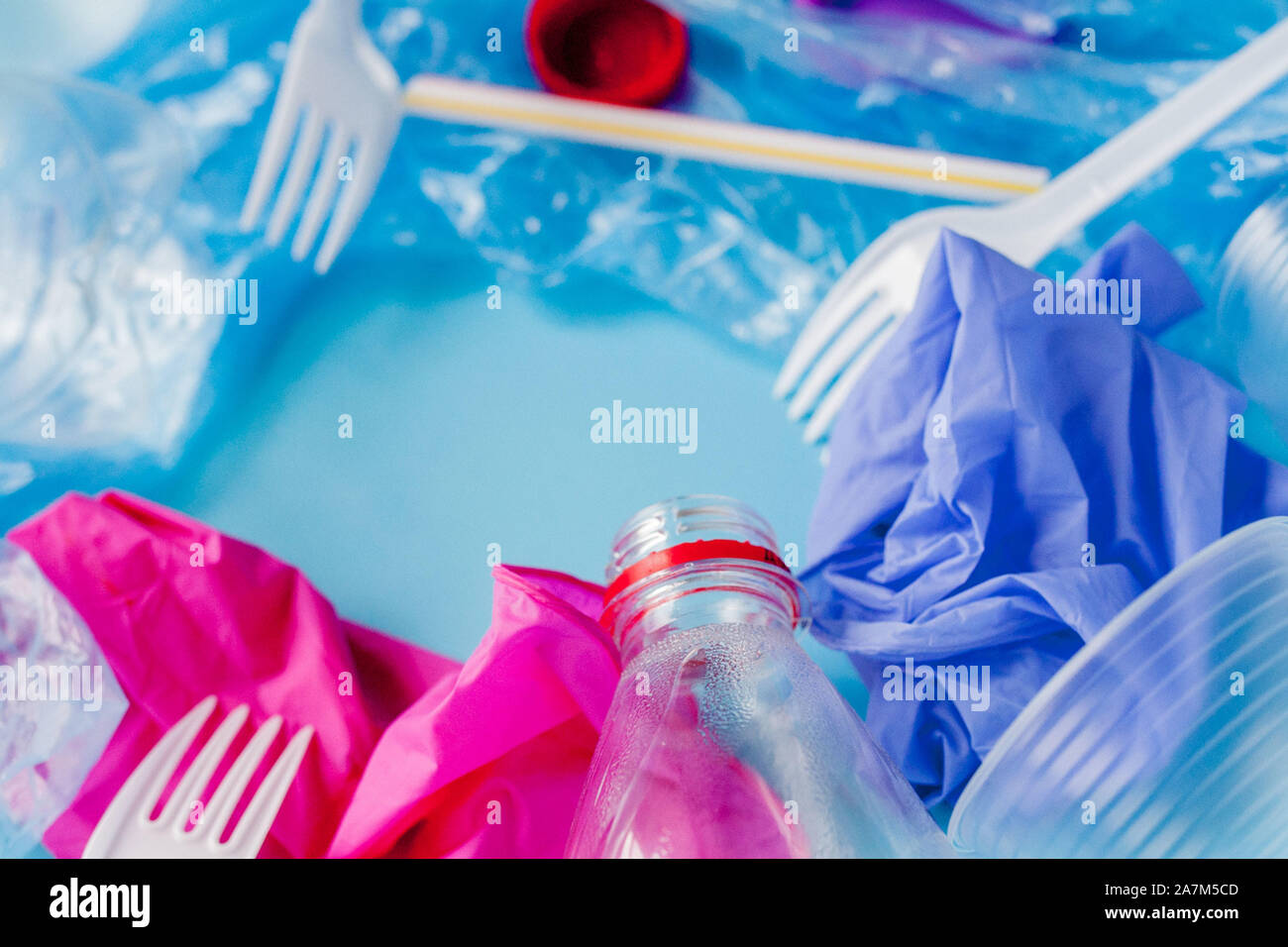Top view of various kinds of disposable plastic waste on blue ...