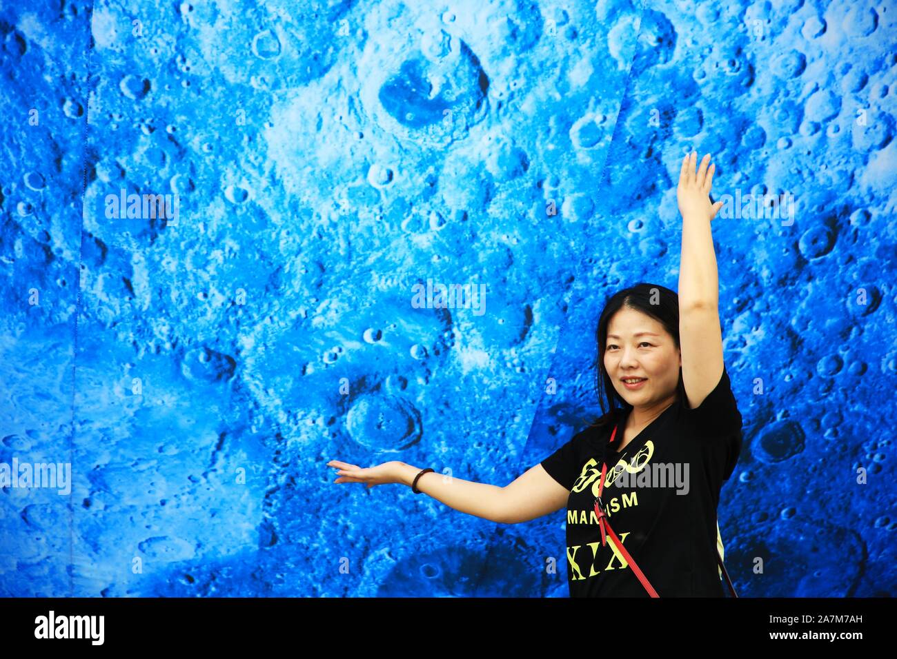People take pictures of the man-made blue moon set up on the street to ...