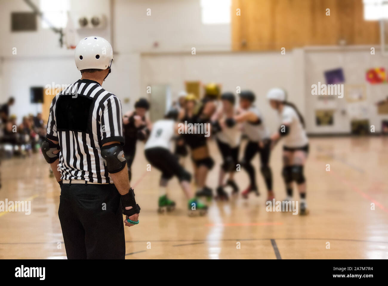 Roller derby referee watches teams for penalties Stock Photo - Alamy