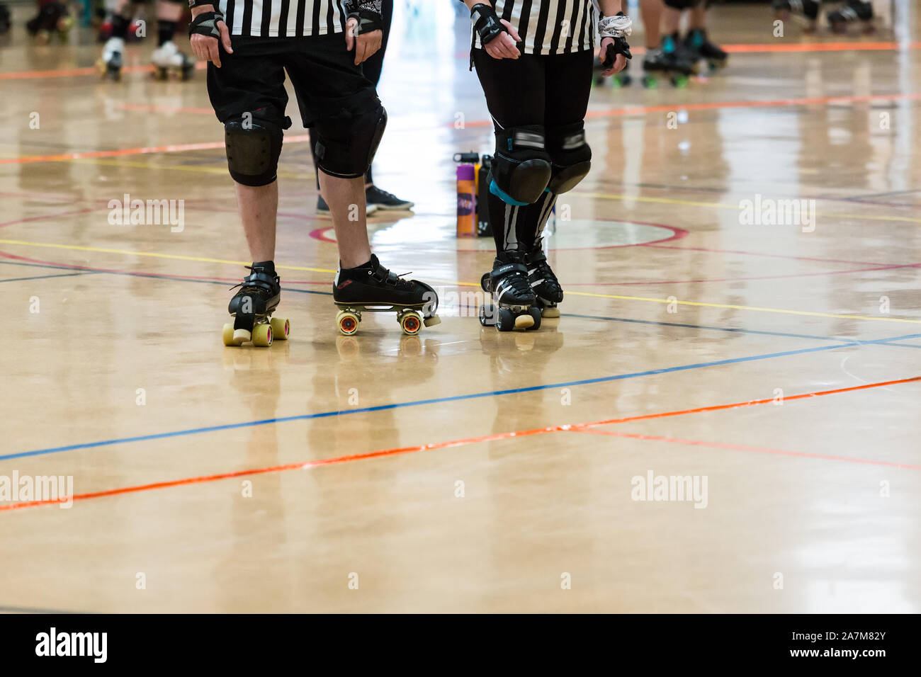 Roller derby referee watches teams for penalties Stock Photo - Alamy