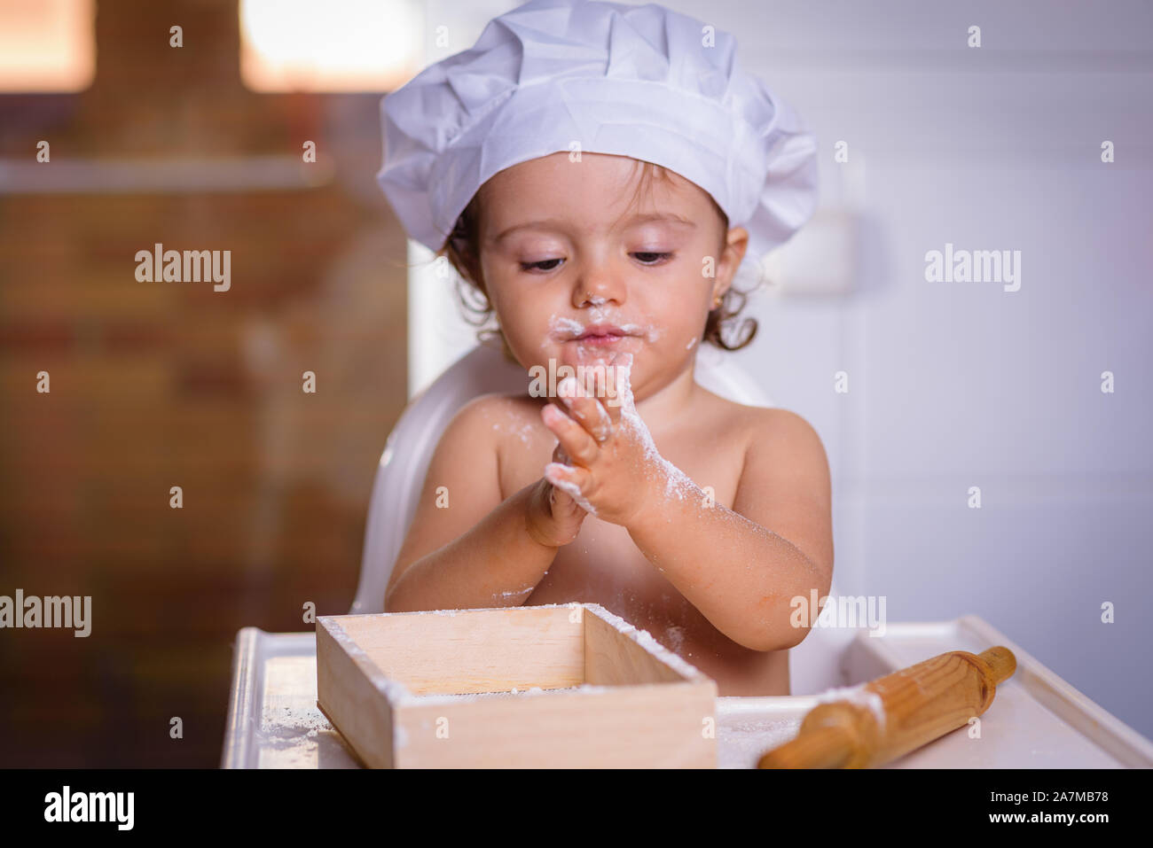 little baker child girl in chef hat at kitchen Stock Photo - Alamy