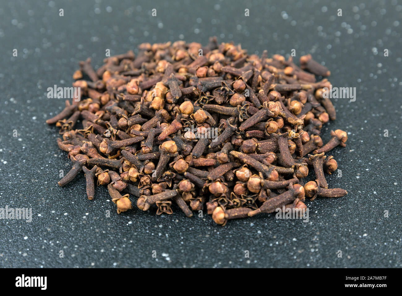 Whole clove heads and pieces isolated over black Stock Photo - Alamy
