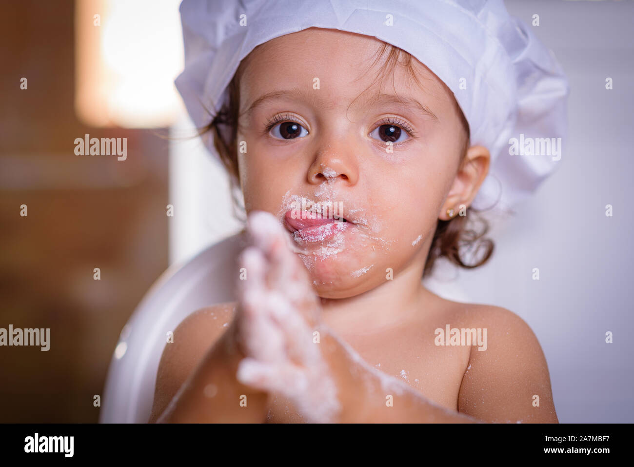 Cooking is fun. Little girl playing with flour Stock Photo - Alamy