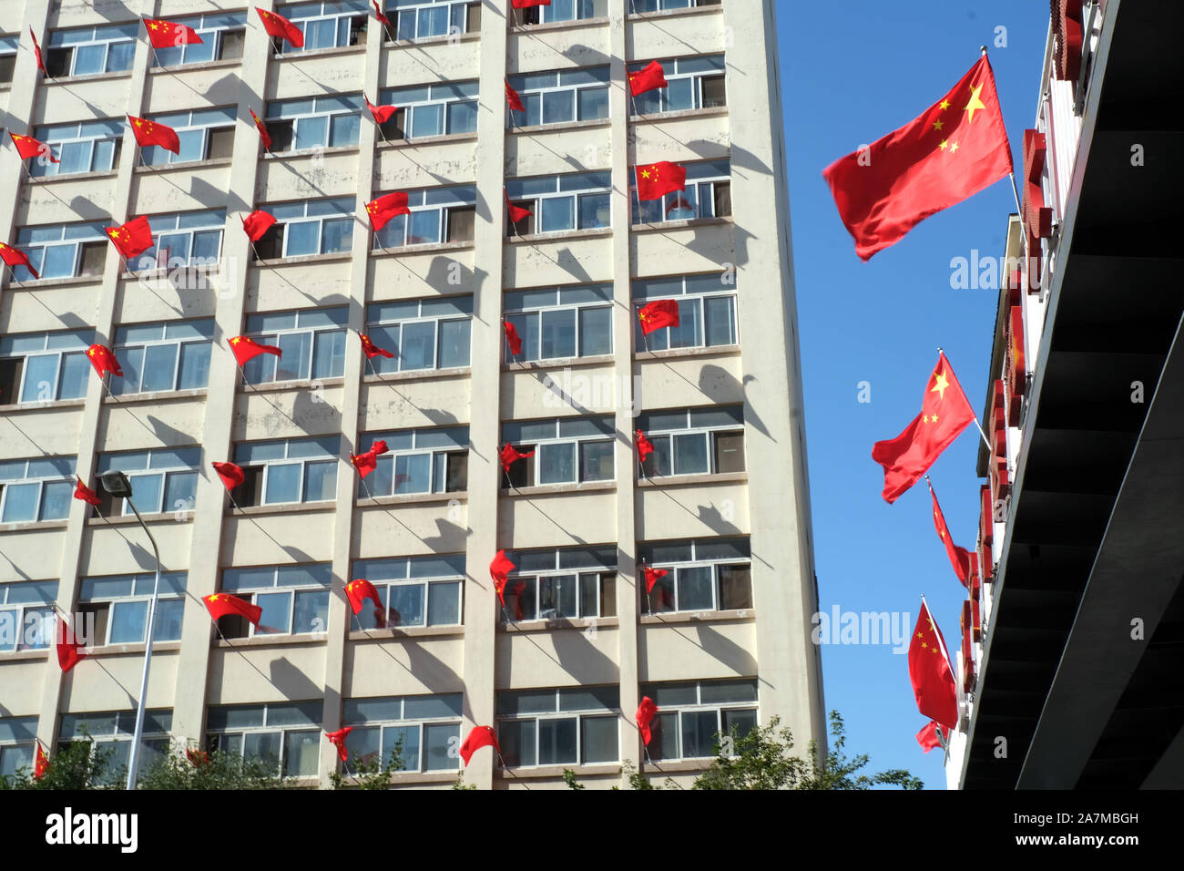 Chinese national flags flutter on the windows at the campus of Liaoning ...