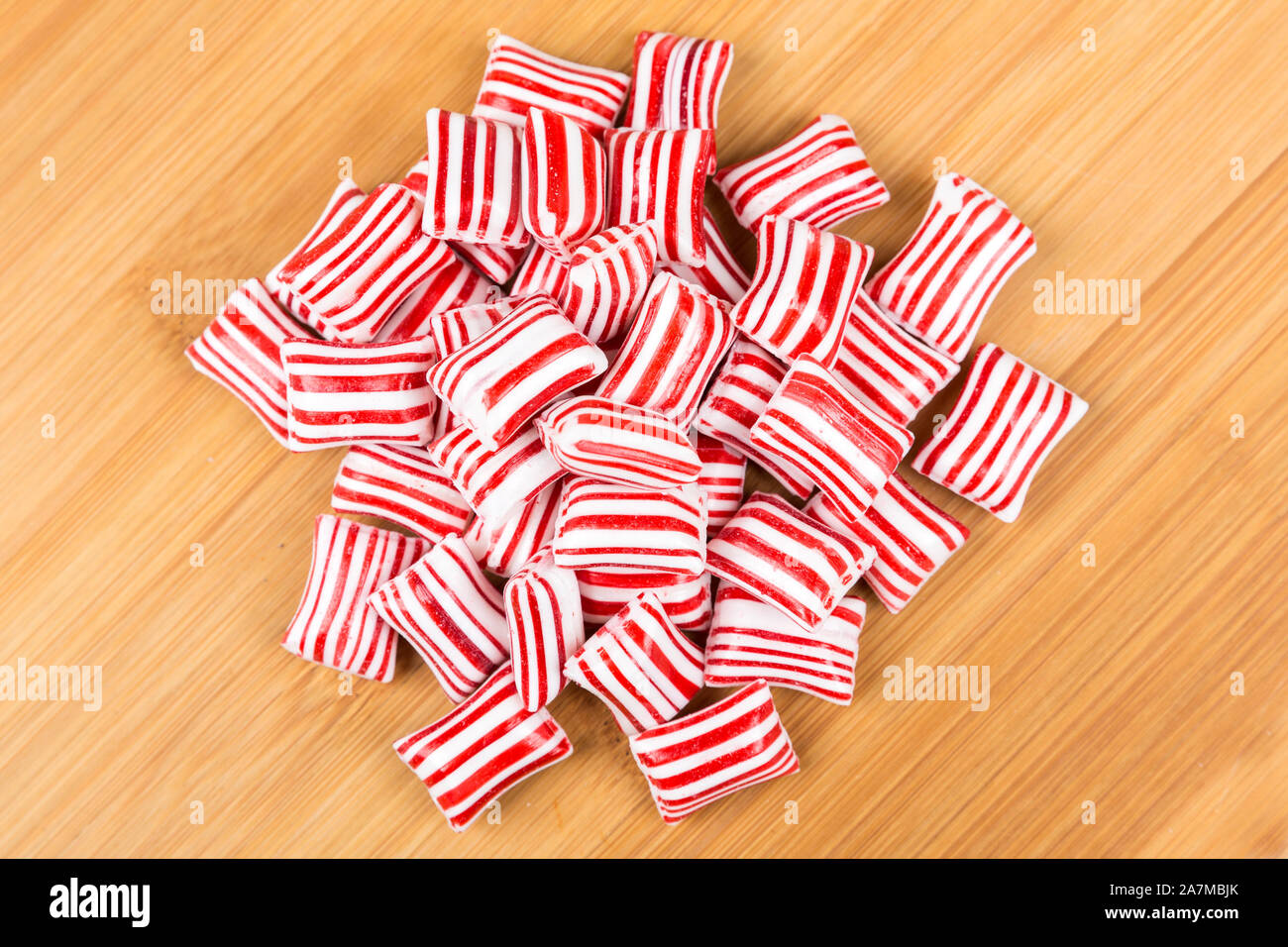 Red and white striped holiday candy isolated over white Stock Photo - Alamy