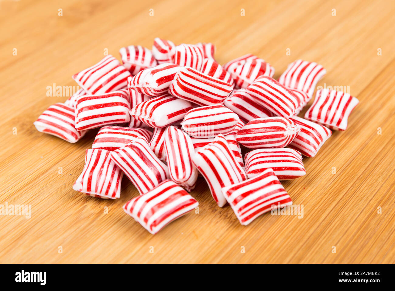 Red and white striped holiday candy isolated over white Stock Photo - Alamy