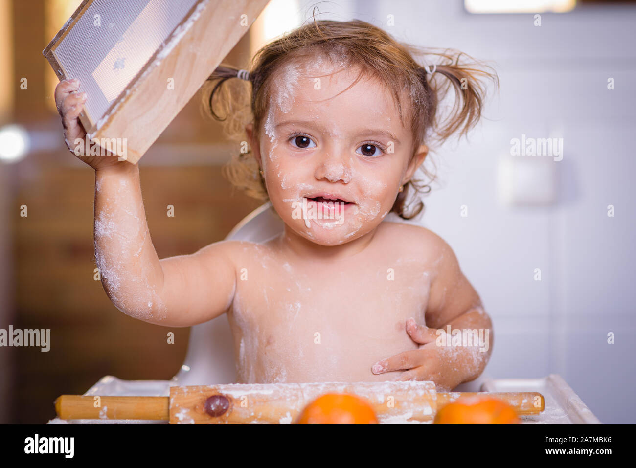 Cooking is fun. Little girl playing with flour Stock Photo - Alamy