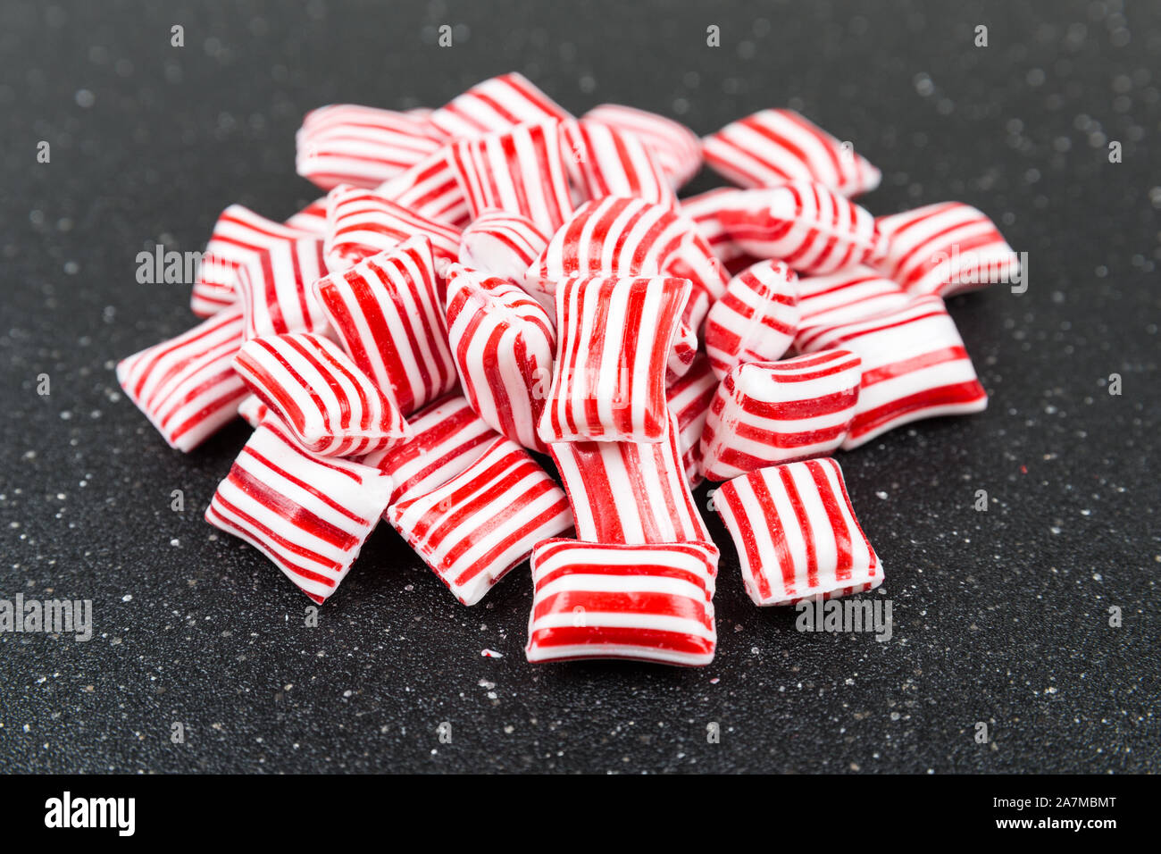 Red and white striped holiday candy isolated over white Stock Photo - Alamy