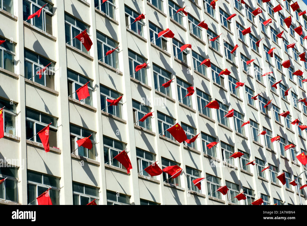 Chinese national flags flutter on the windows at the campus of Liaoning ...