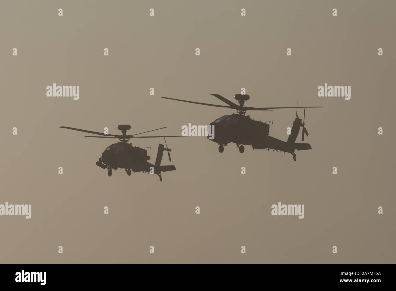 Two Military choppers in combat and war flying into the smoke and chaos ...