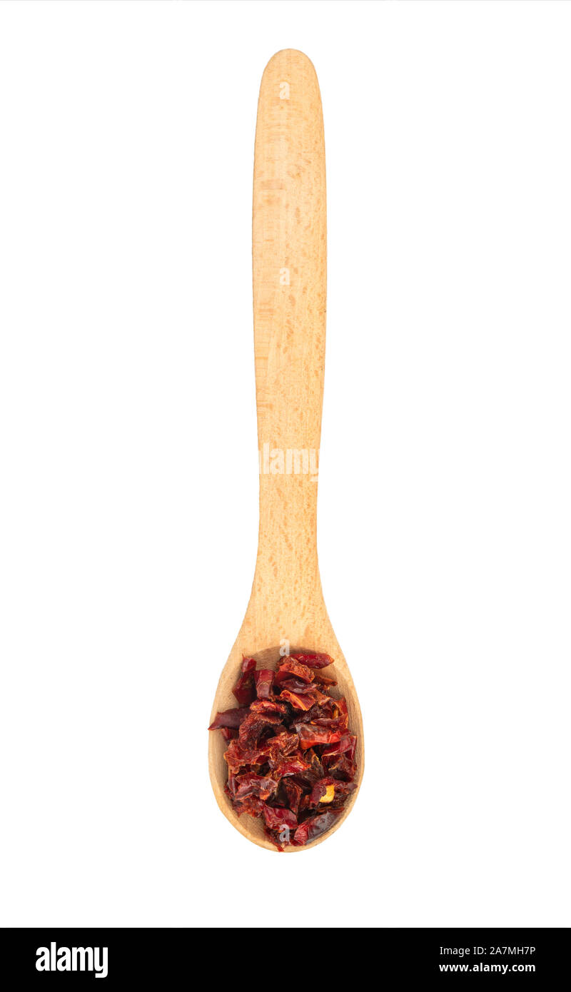 Pieces of dry red pepper in a small spoon on a white background, top ...
