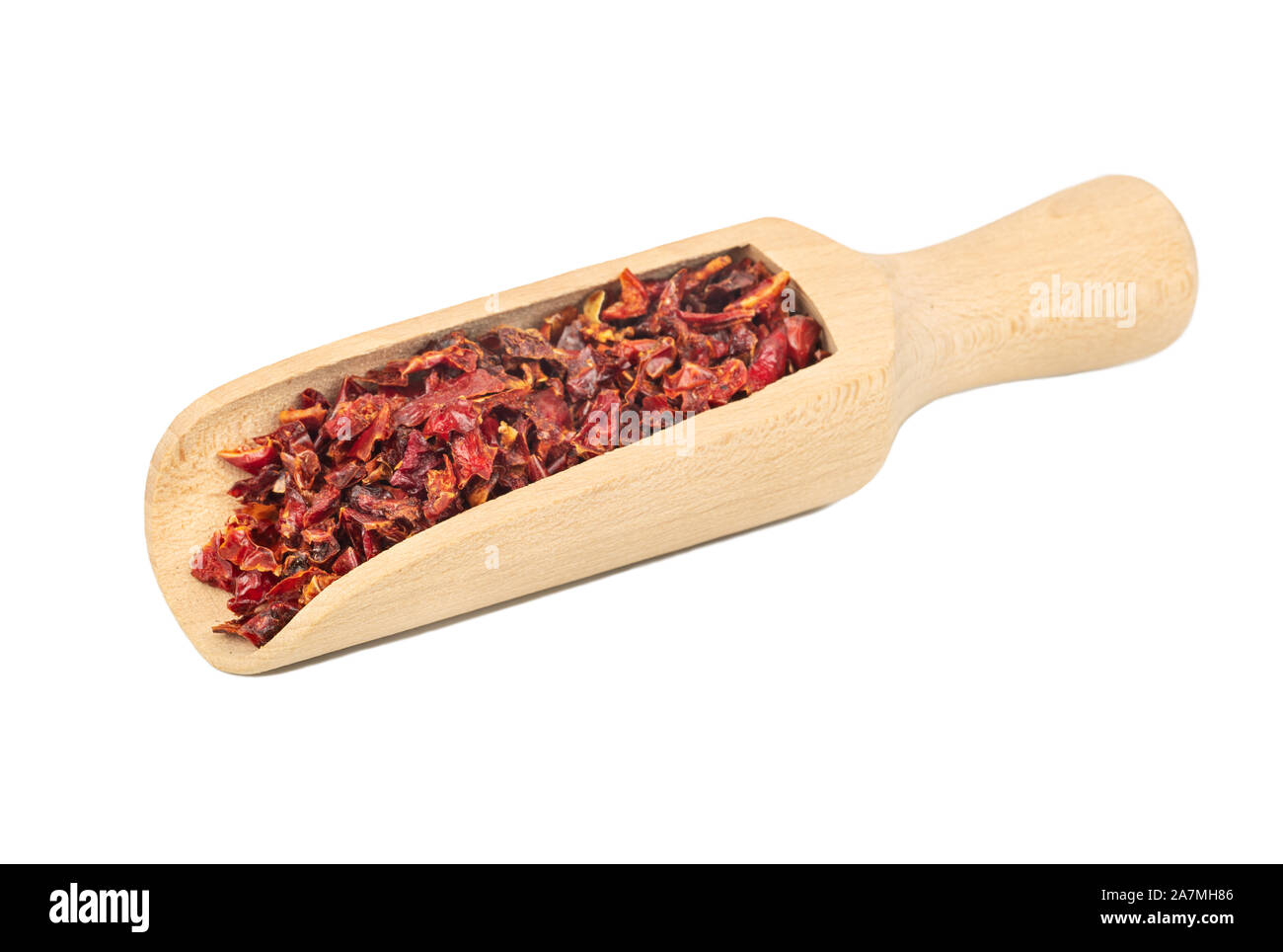 Pieces of dry red pepper in a wooden scoop on a white background Stock ...