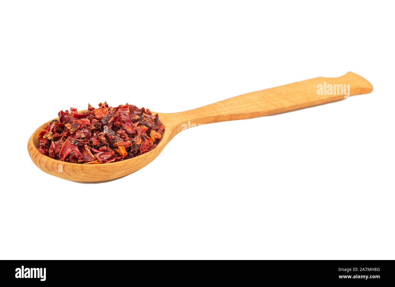 Pieces of dry red pepper in a large spoon isolated on white background ...
