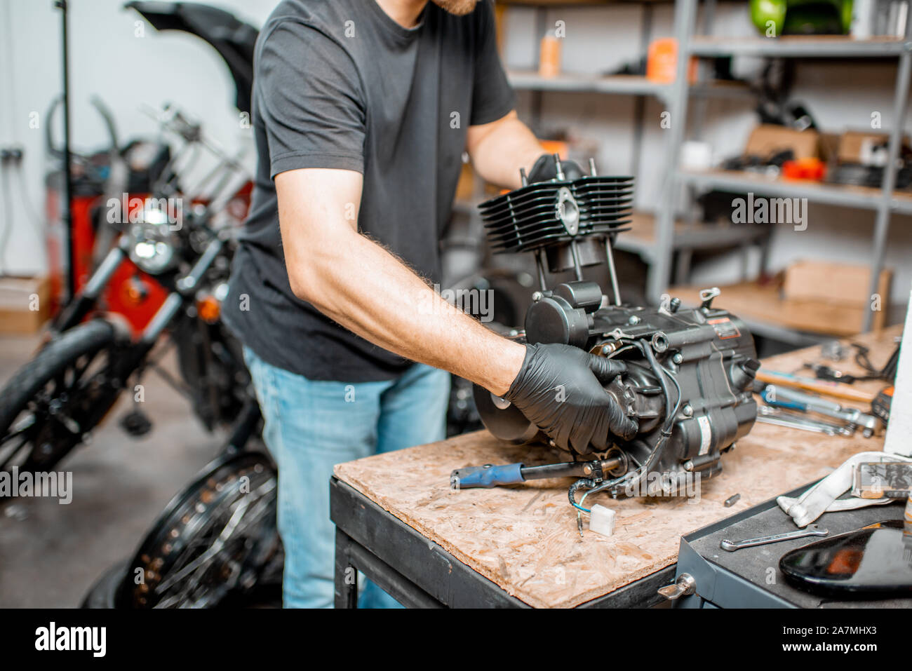 Workman disassembling motorcycle engine during a repairment at the ...