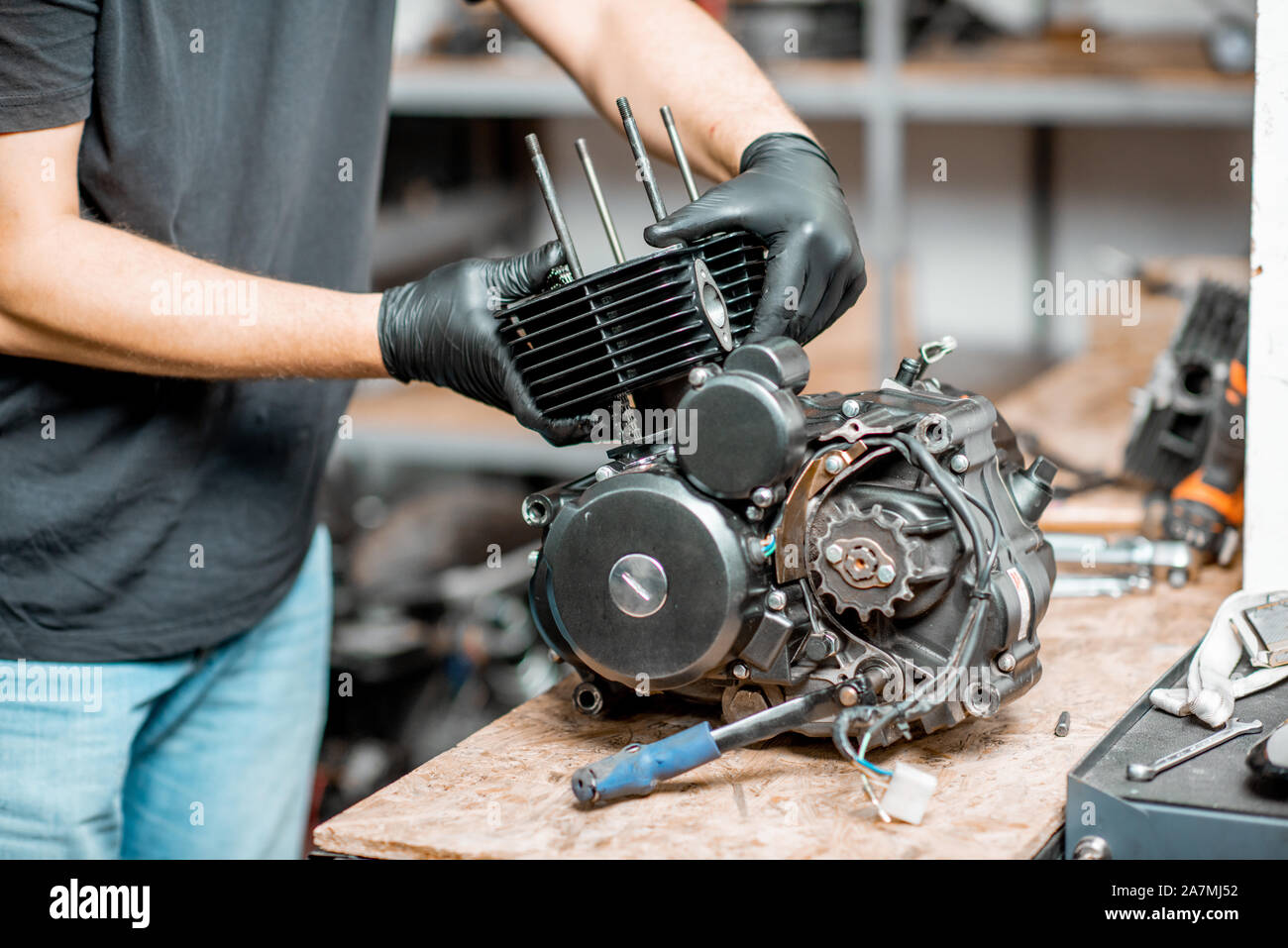 Workman disassembling motorcycle engine during a repairment at the ...