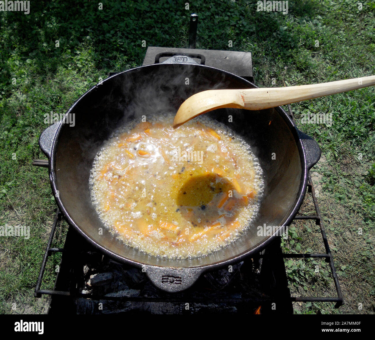 Cast iron bowl pilaf, wide black plate is filled with various homemade ...