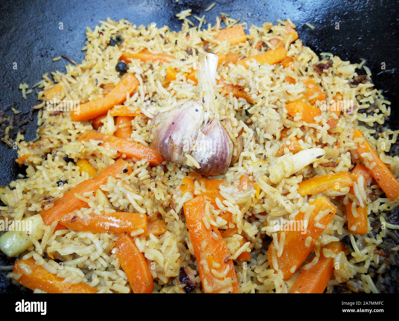 Cast iron bowl pilaf, wide black plate is filled with various homemade ...