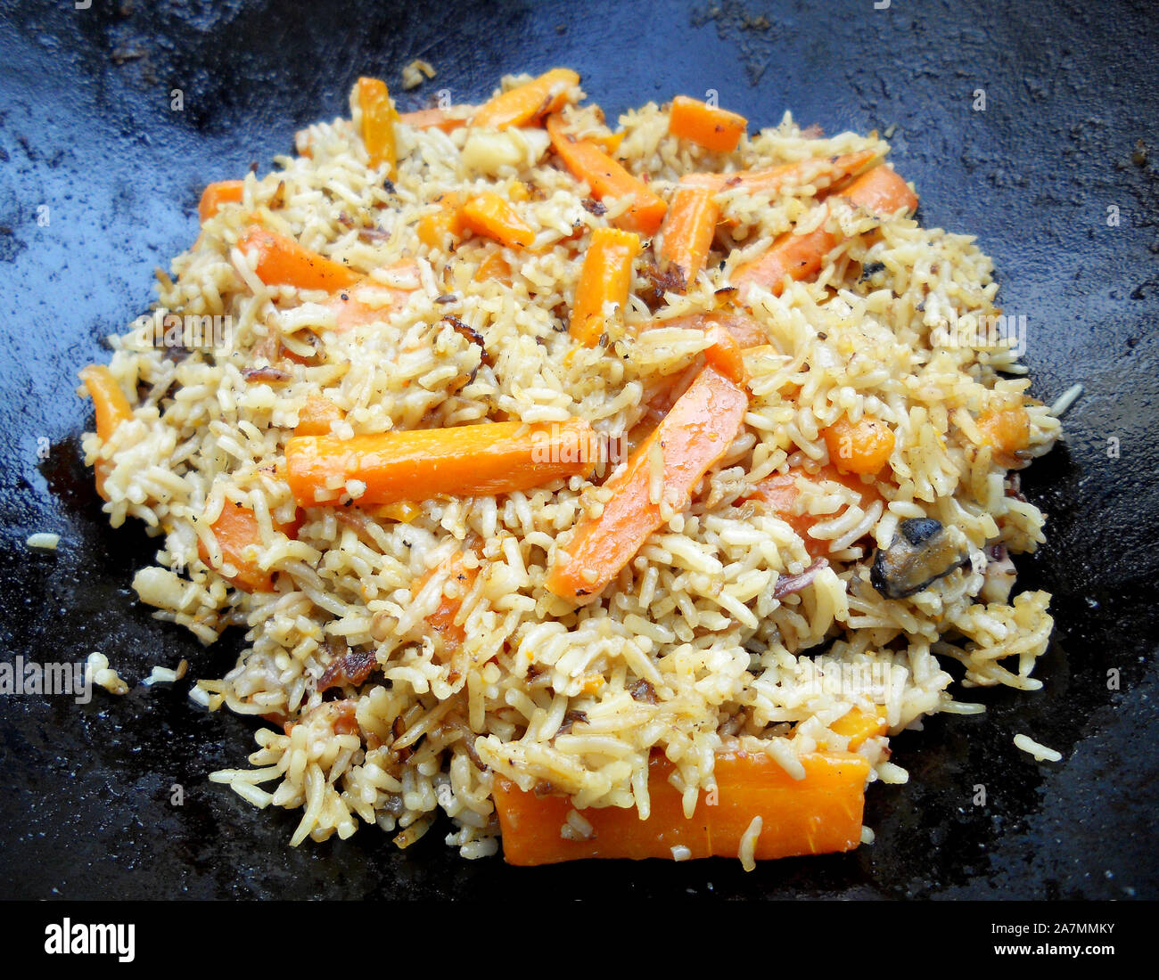 Cast iron bowl pilaf, wide black plate is filled with various homemade ...