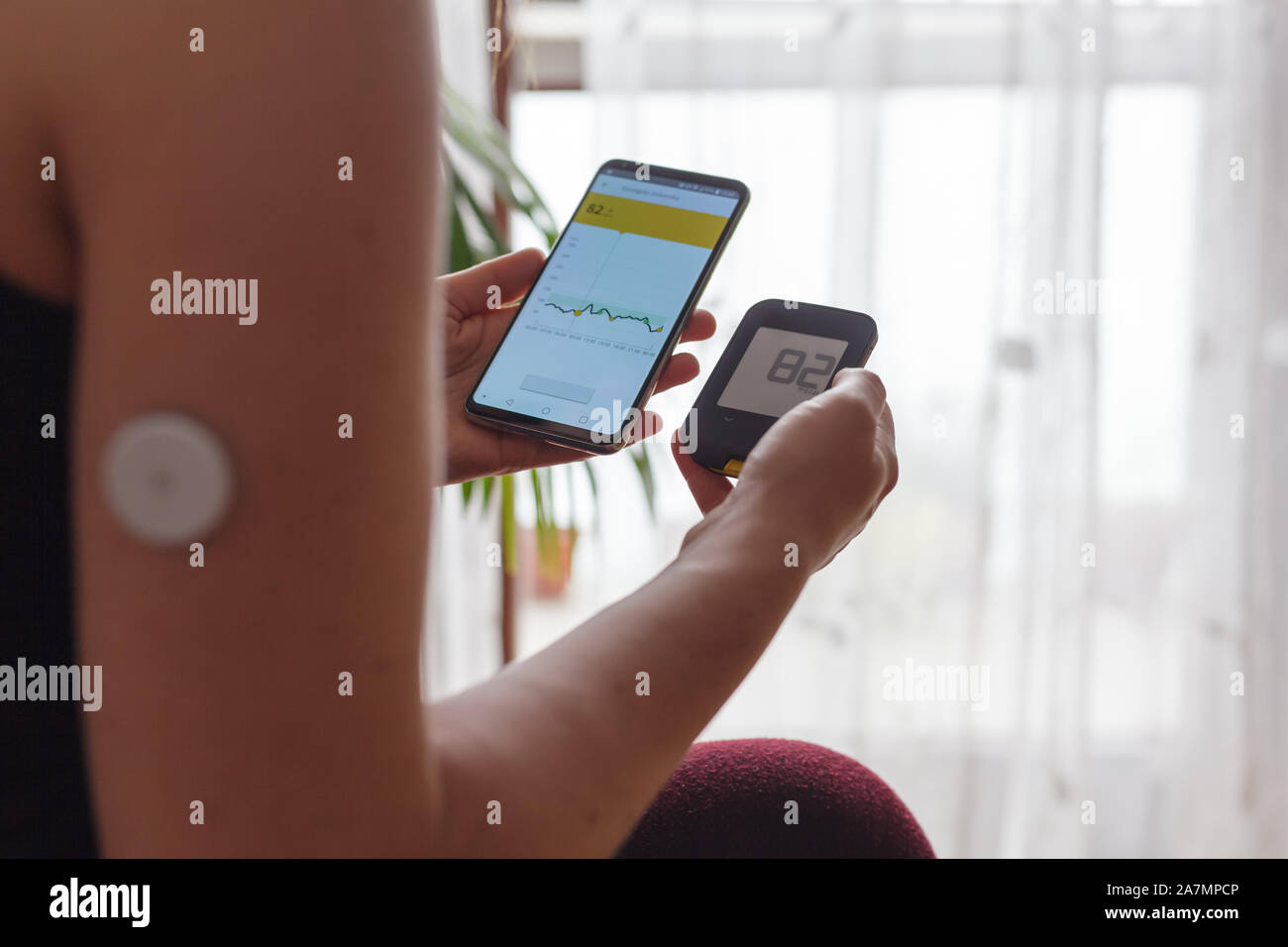 Woman comparing result of glucose level check on the traditional ...