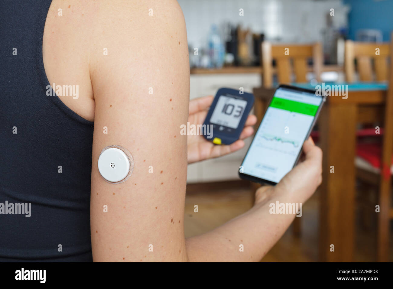 Woman comparing result of glucose level check on the traditional ...