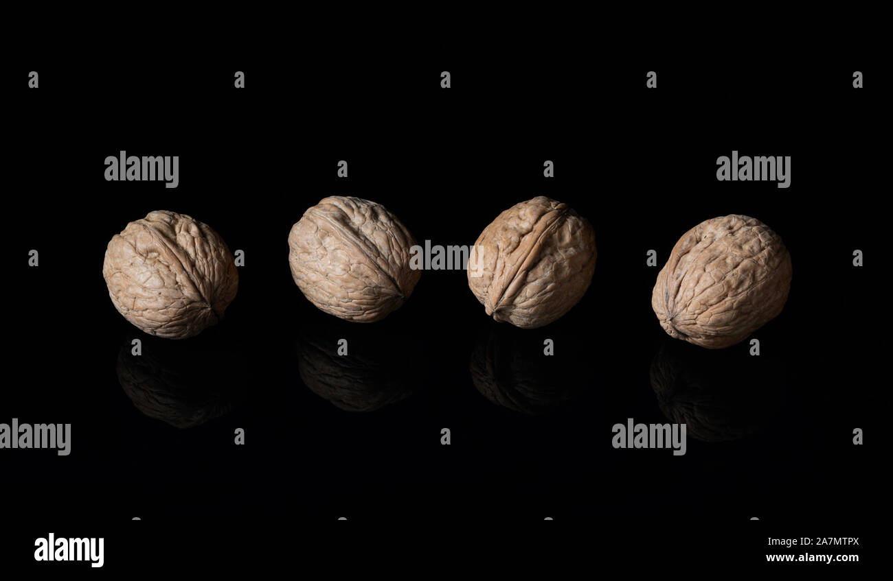 Walnuts in their shells on black reflective surface Stock Photo - Alamy