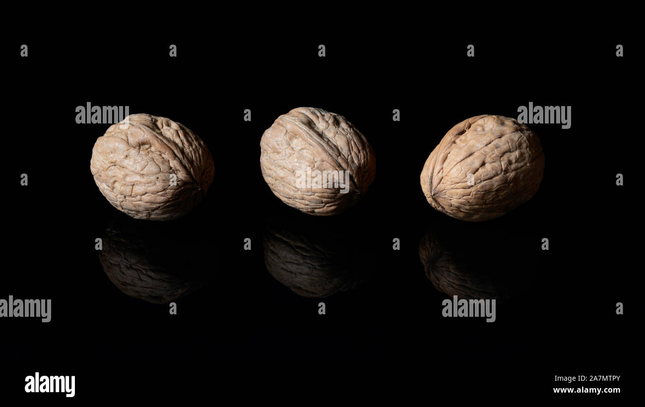 Walnuts in their shells on black reflective surface Stock Photo - Alamy