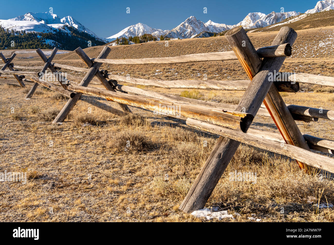 Lost river range in Idaho with snow in foreground a round pole fence ...