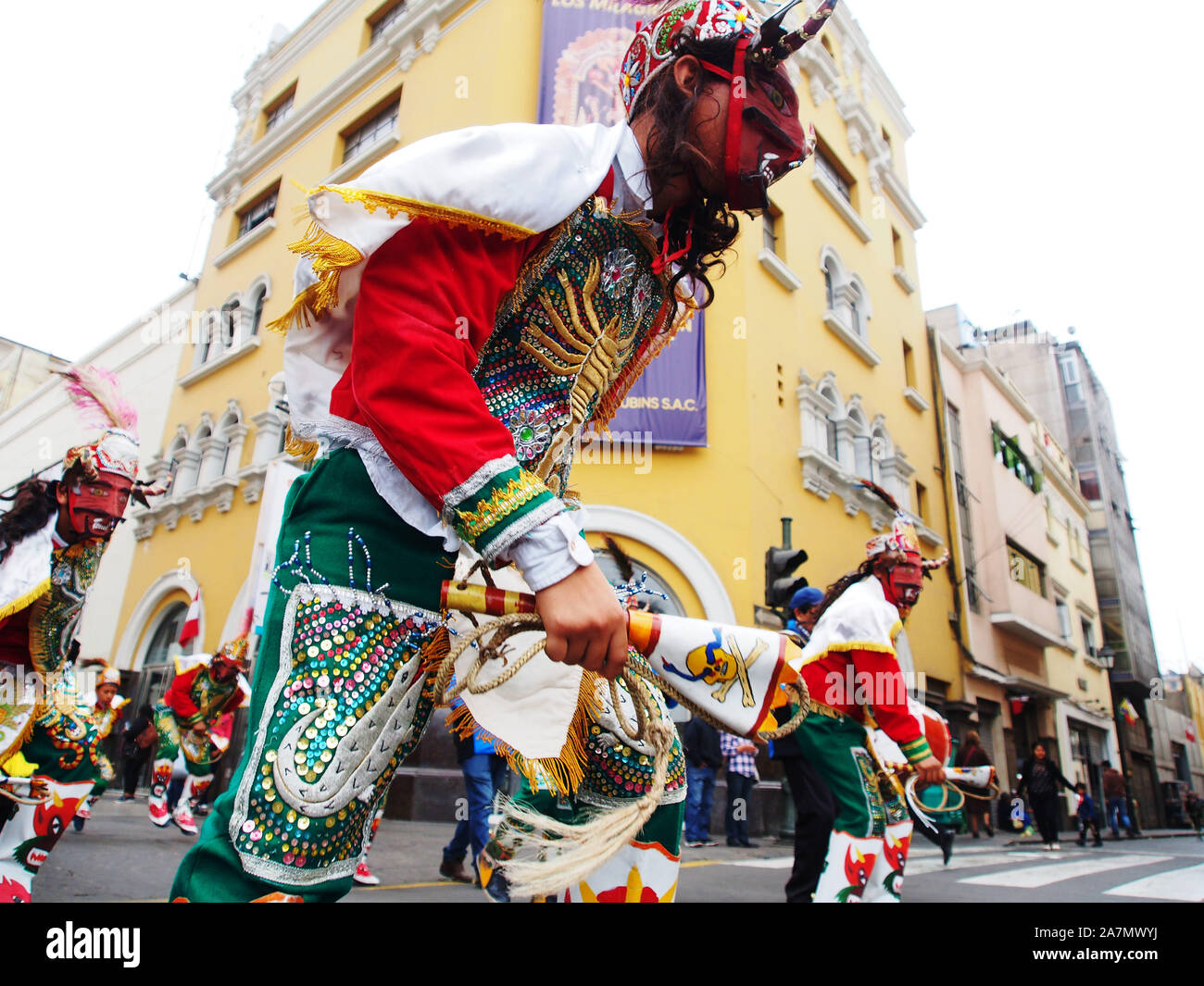 A masked folk dancer wearing typical costume participating in the ...