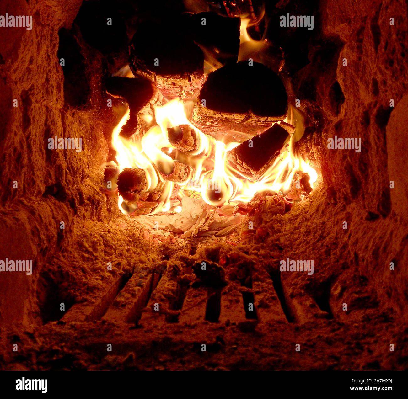 Beautiful red fire from slice wood, dark grey black coals inside metal ...