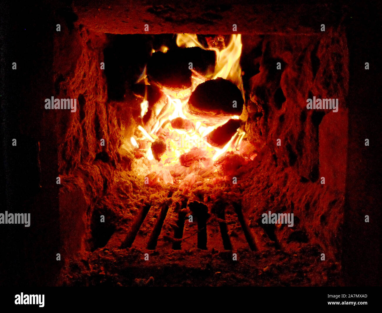 Beautiful red fire from slice wood, dark grey black coals inside metal ...