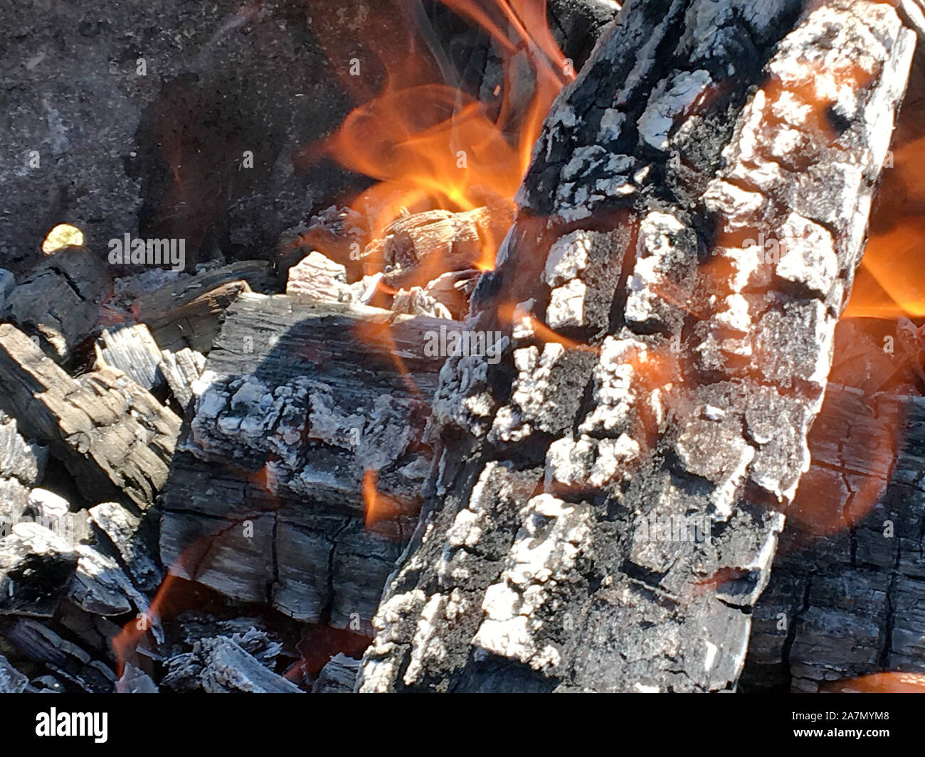 Beautiful red flame from slice wood, dark grey black coals inside metal ...