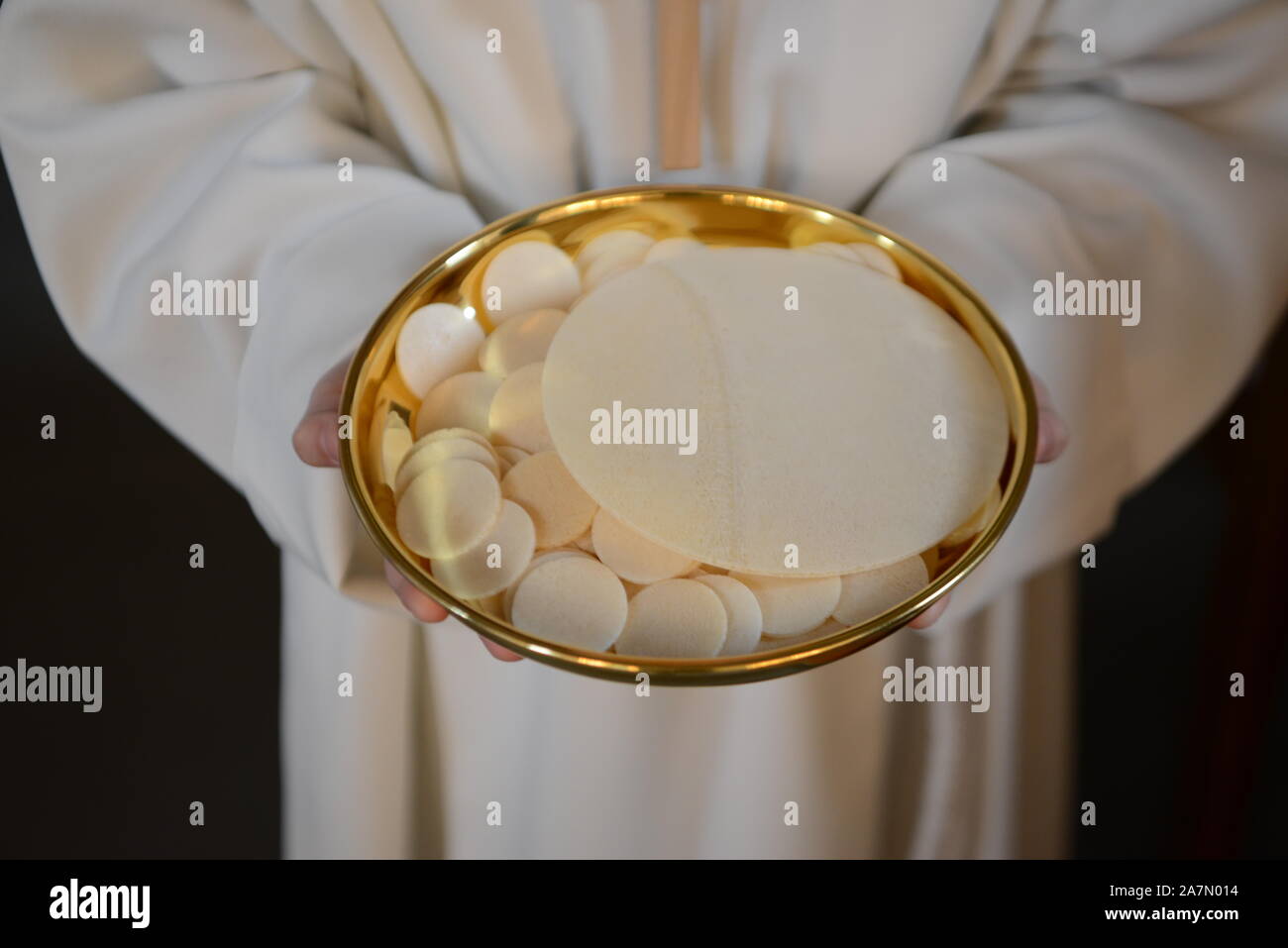 Catholic Altar Boy hold altar bread Stock Photo - Alamy